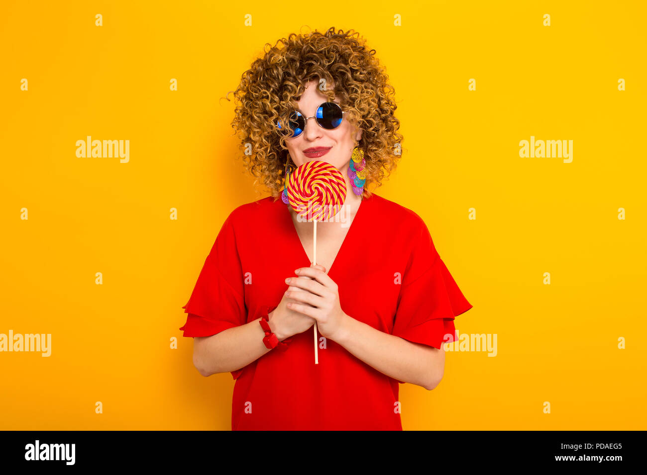 Attractive woman with short curly hair with candy Stock Photo - Alamy