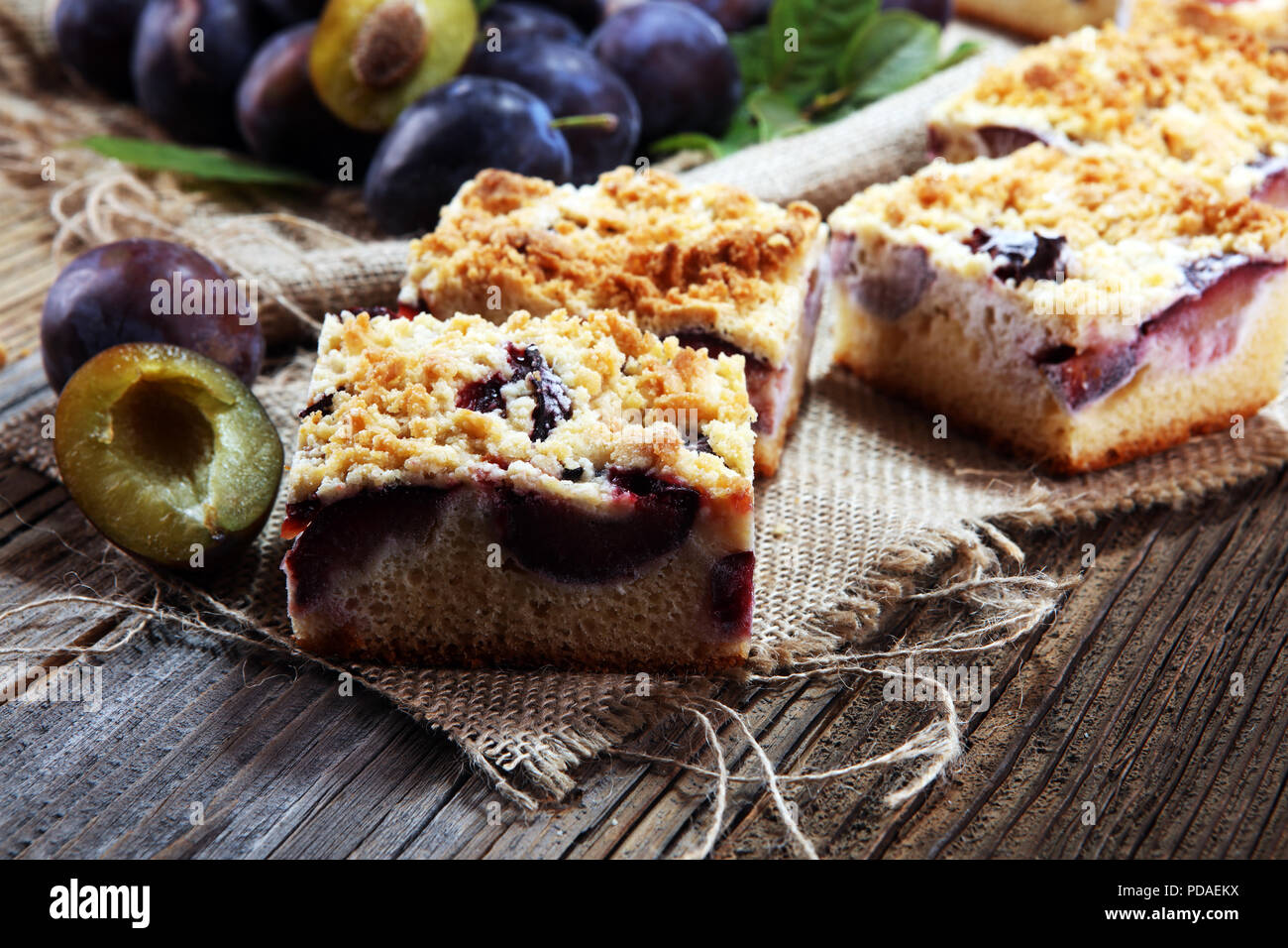 Rustic plum cake on wooden background with plums around Stock Photo - Alamy