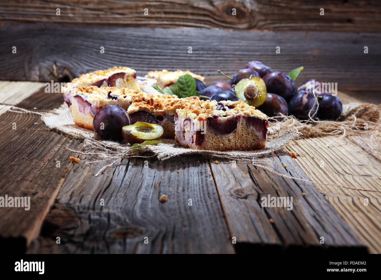 Rustic plum cake on wooden background with plums around Stock Photo - Alamy