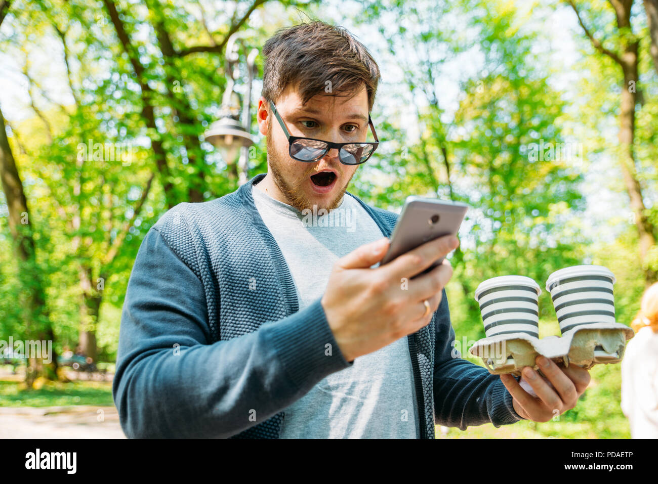 man looking on phone with pop-eyed view. coffee to go in hands Stock ...