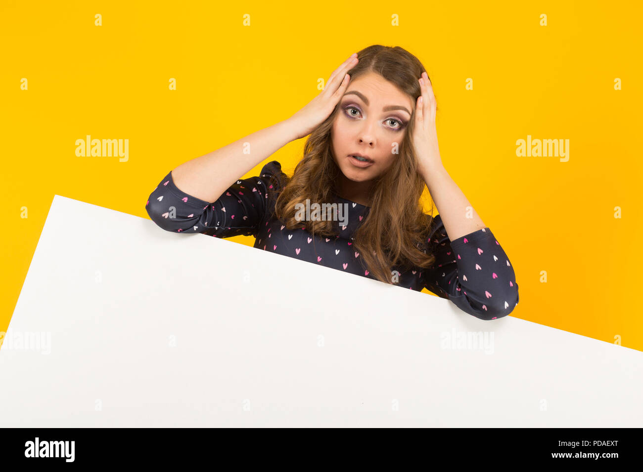 Attractive shocked woman with blank banner Stock Photo - Alamy