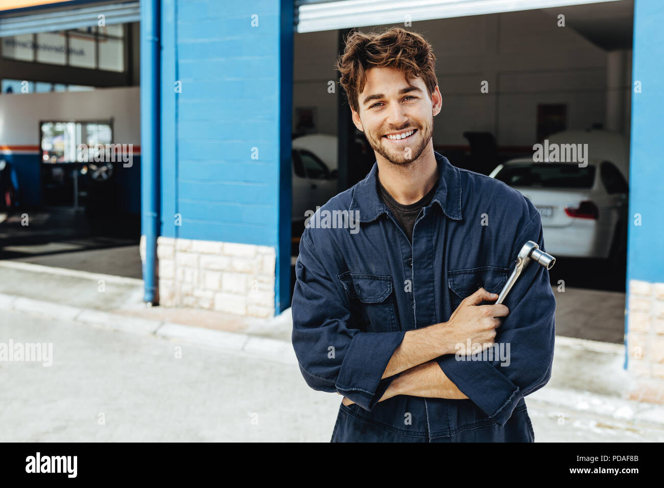 Professional auto mechanic in uniform with wrench. Young mechanic ...