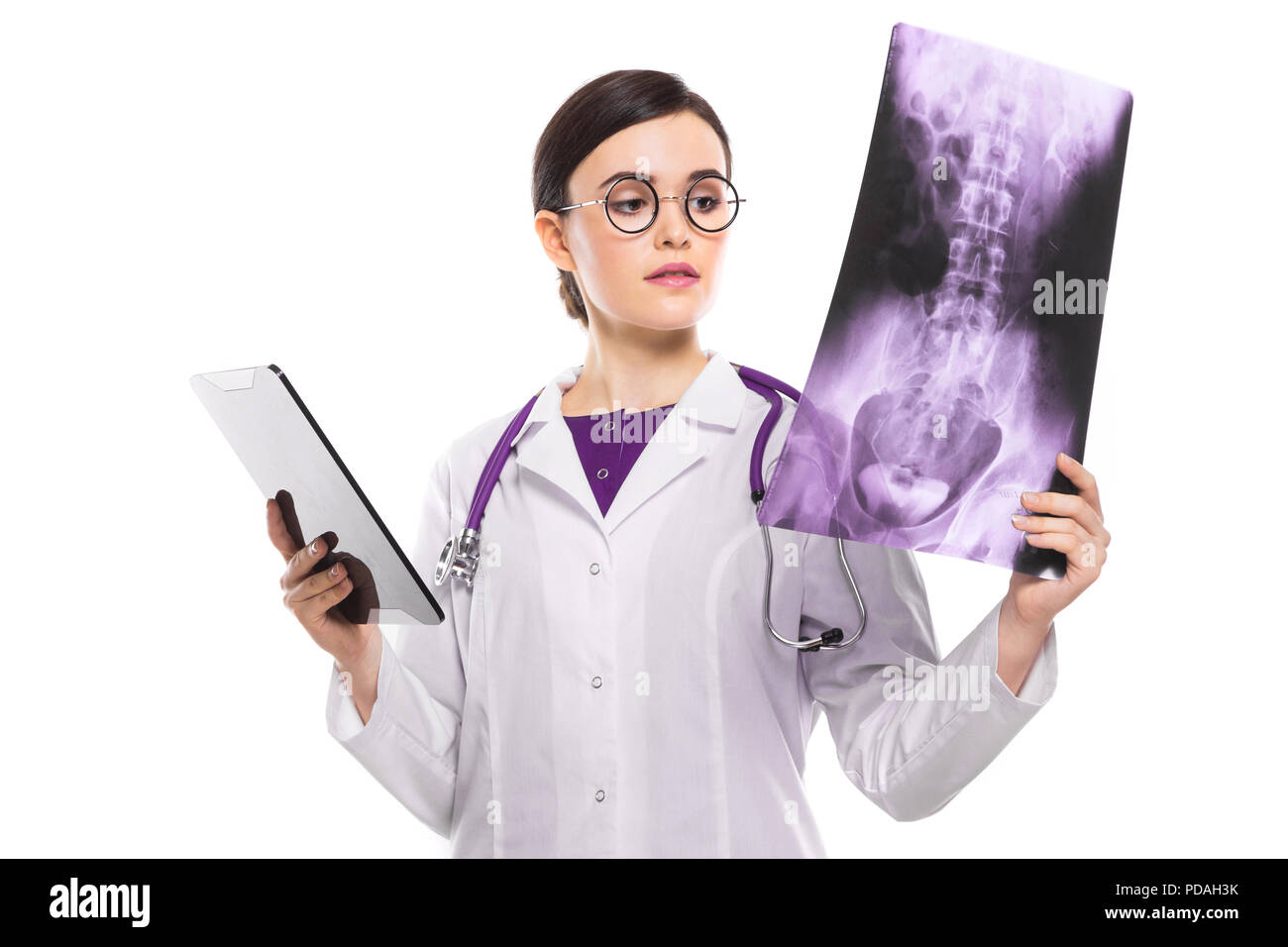 Young woman doctor with stethoscope looking at x-ray making diagnosis ...
