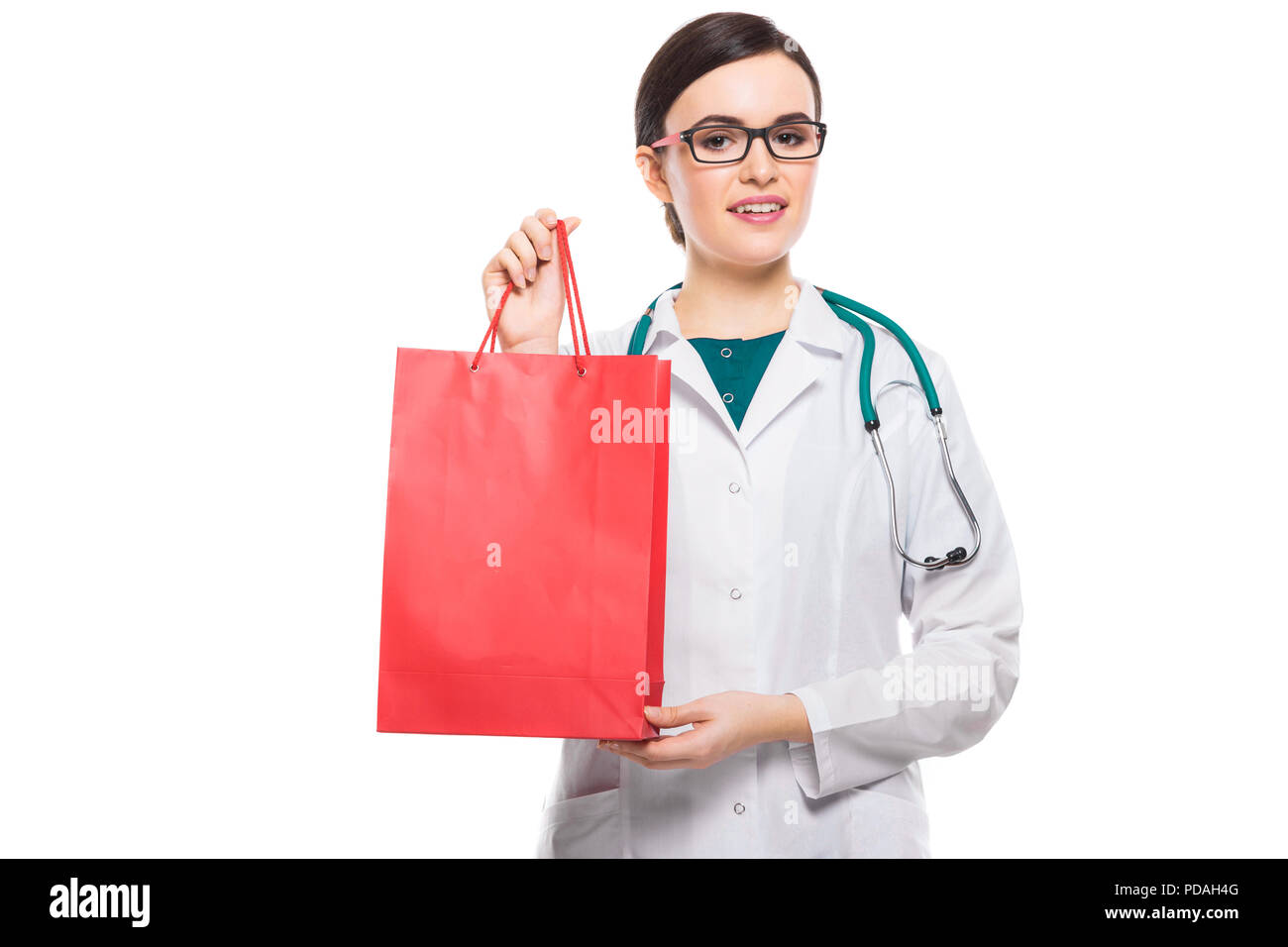 Successful young woman doctor with stethoscope offering shopping bag in ...
