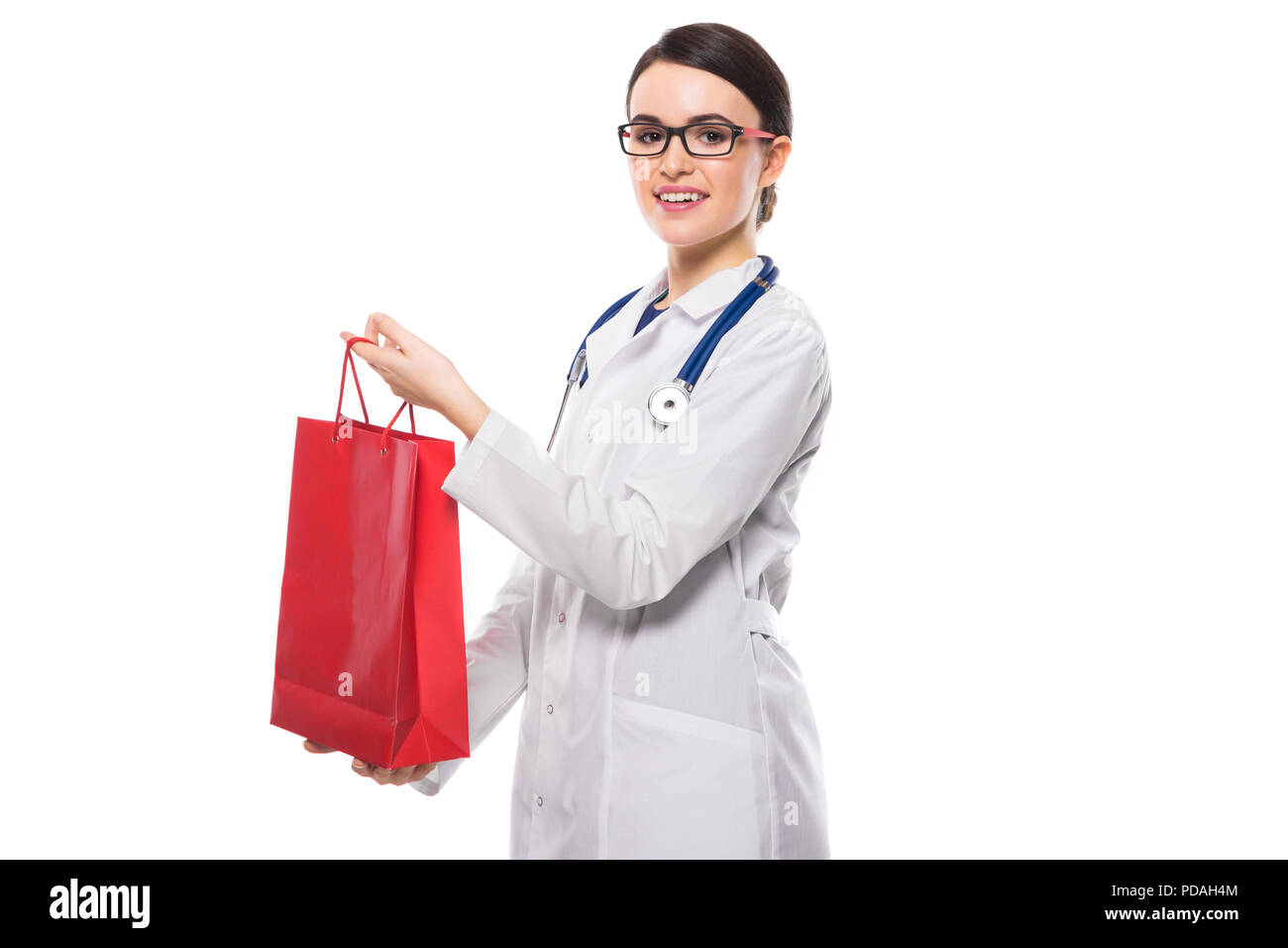 Successful young woman doctor with stethoscope offering shopping bag in ...