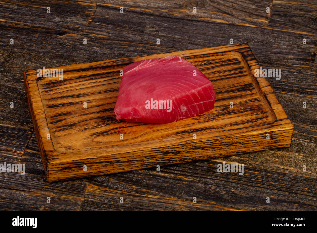 Raw tuna steak over wooden background Stock Photo - Alamy