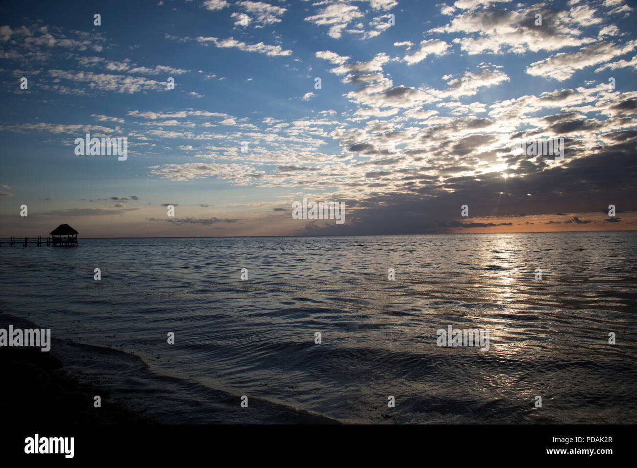 Clouds and ocean with sun rising over the water Stock Photo - Alamy