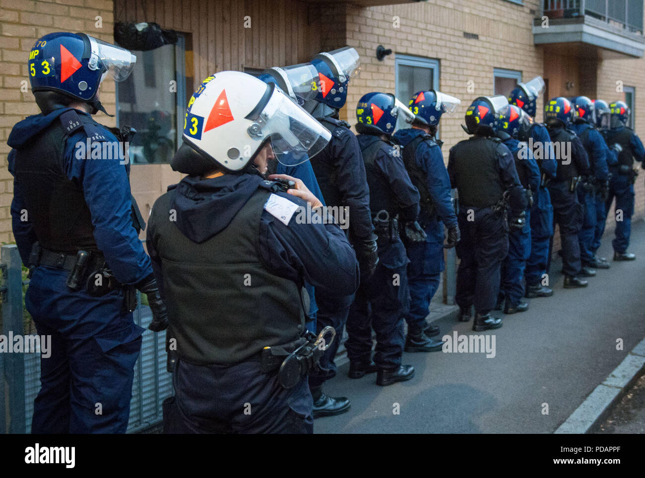 Police officers prepare to raid an address in Peckham, south London ...