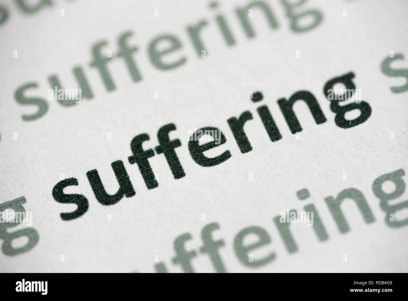 word suffering printed on white paper macro Stock Photo - Alamy