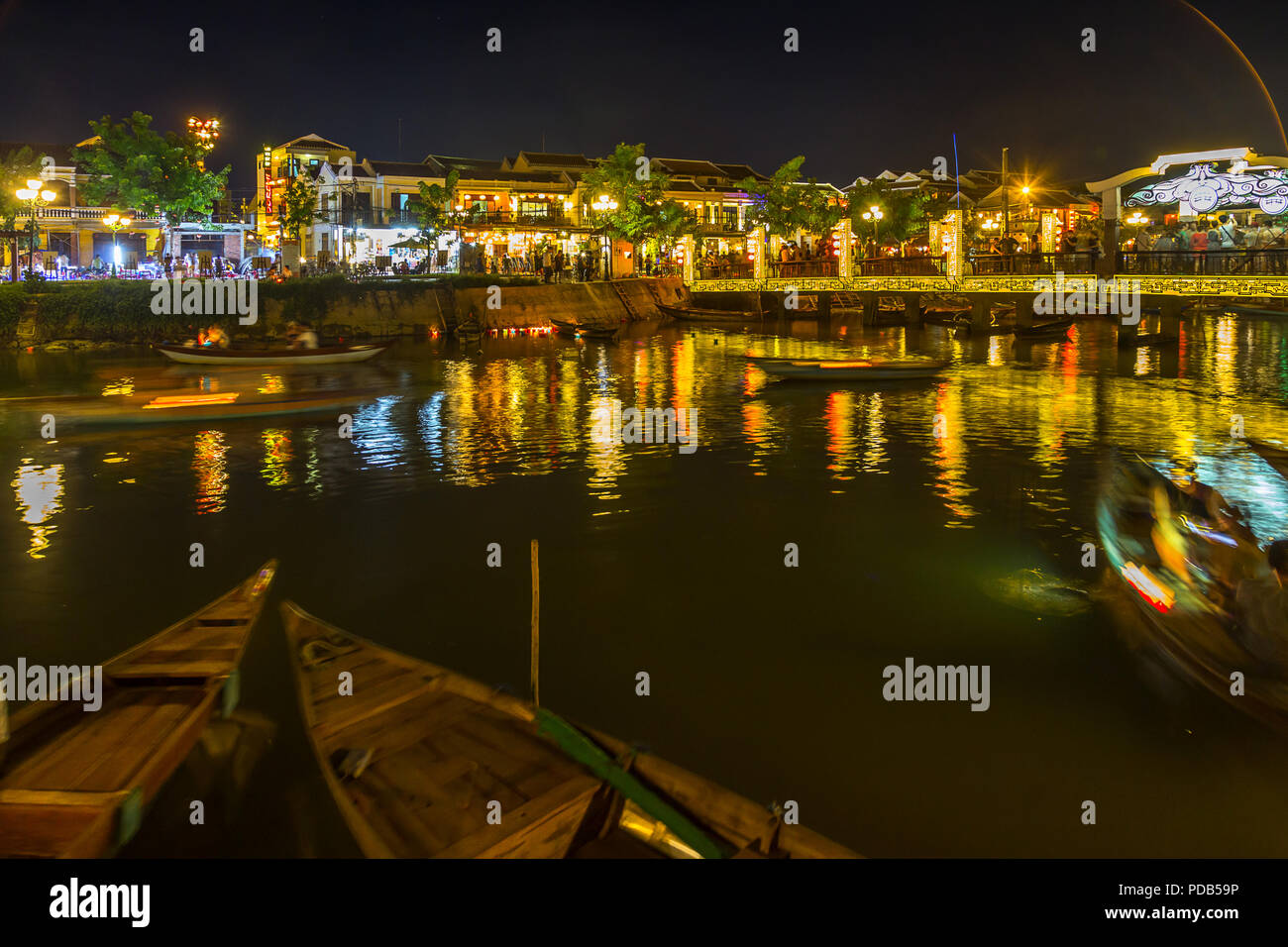 Boats and bridge with waterfront stores all lit up at night Stock Photo ...