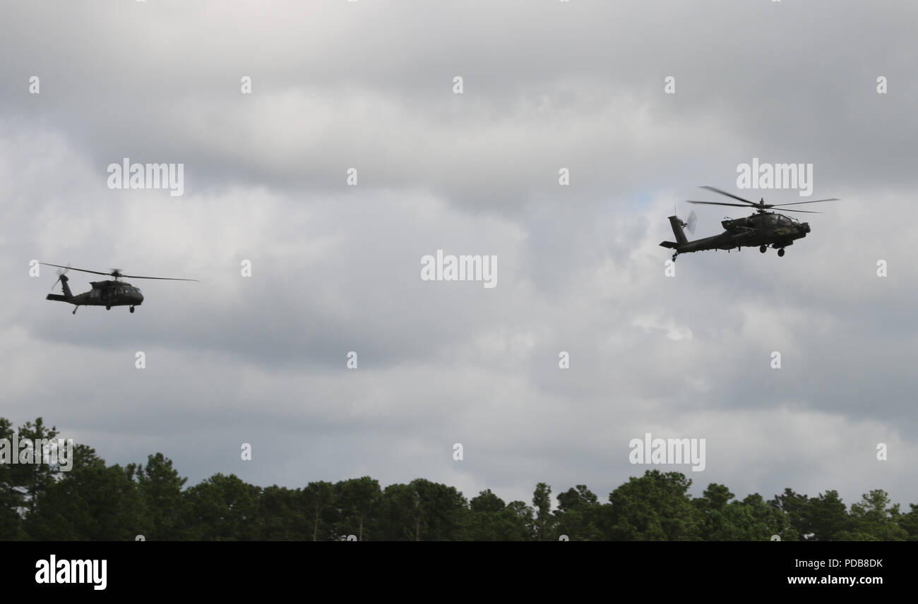 An AH-64 Apache and a UH-60 Blackhawk helicopter fly overhead during ...