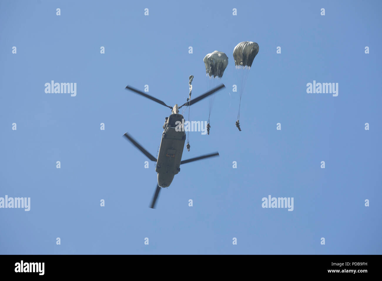 Paratroopers descend from a CH-47 Chinook helicopter onto Castle Drop ...