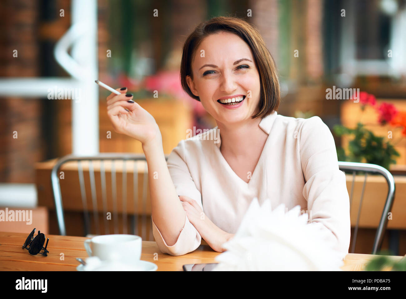 Young woman smokes tobacco in a cafe Stock Photo - Alamy