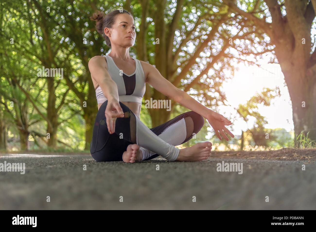 woman sitting meditating outside with trees Stock Photo - Alamy