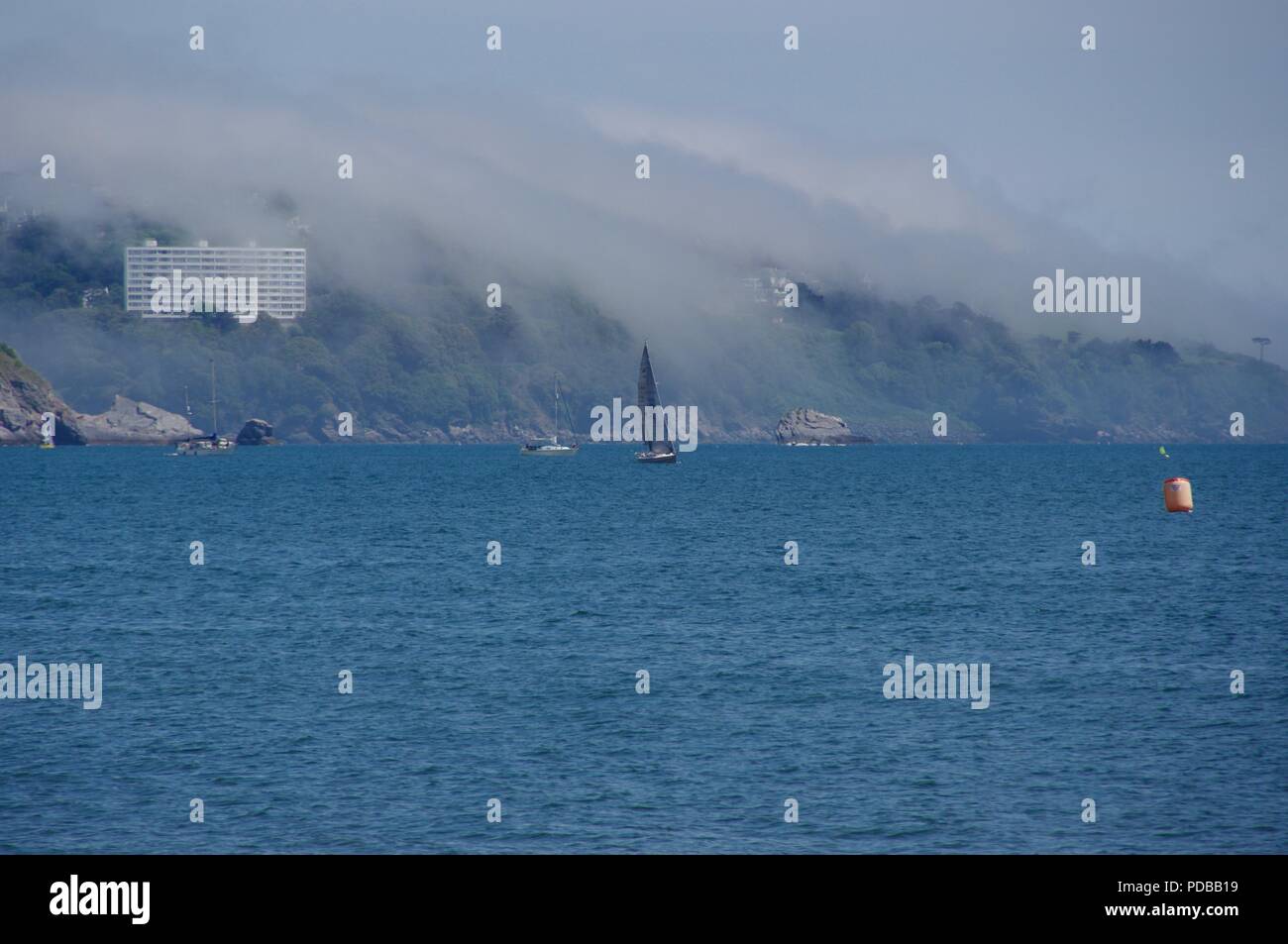 Advection Sea Fog Rolling over Cliff and Hotel. Yacht Sailing on the ...