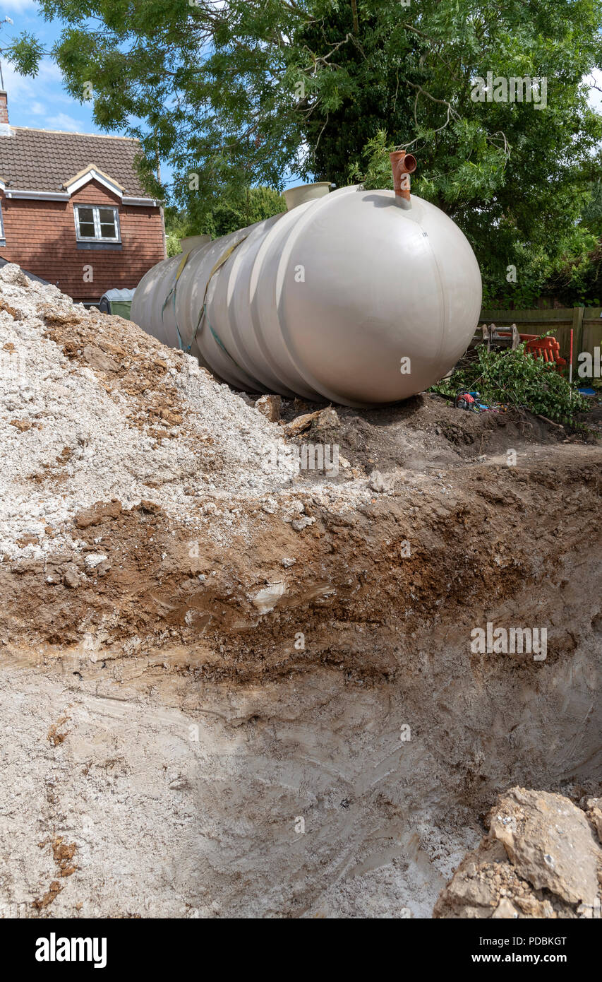 A Excuvator crawler digging a trench for an underground tank on a ...