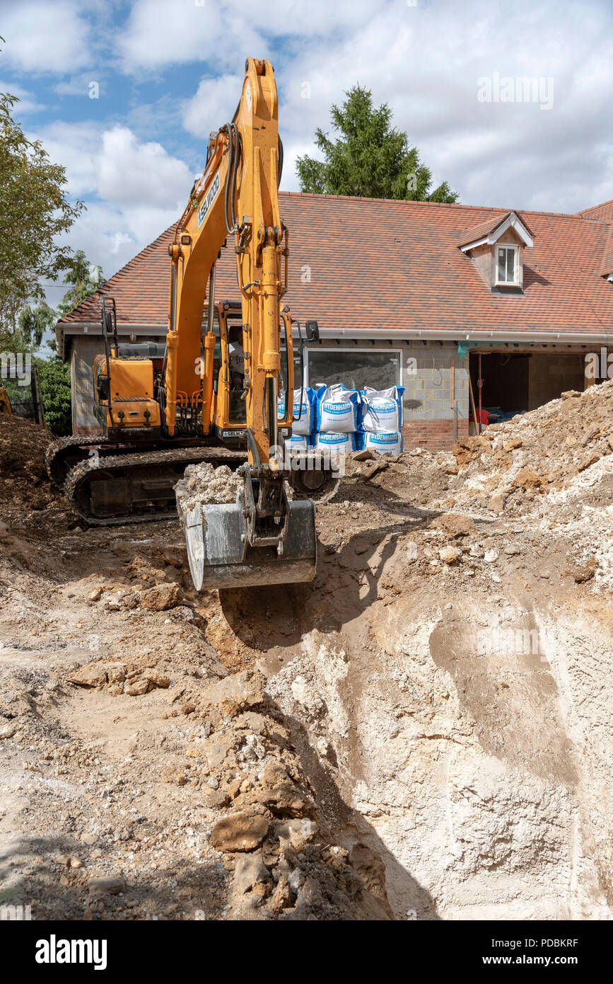 A Excuvator crawler digging a trench for an underground tank on a ...