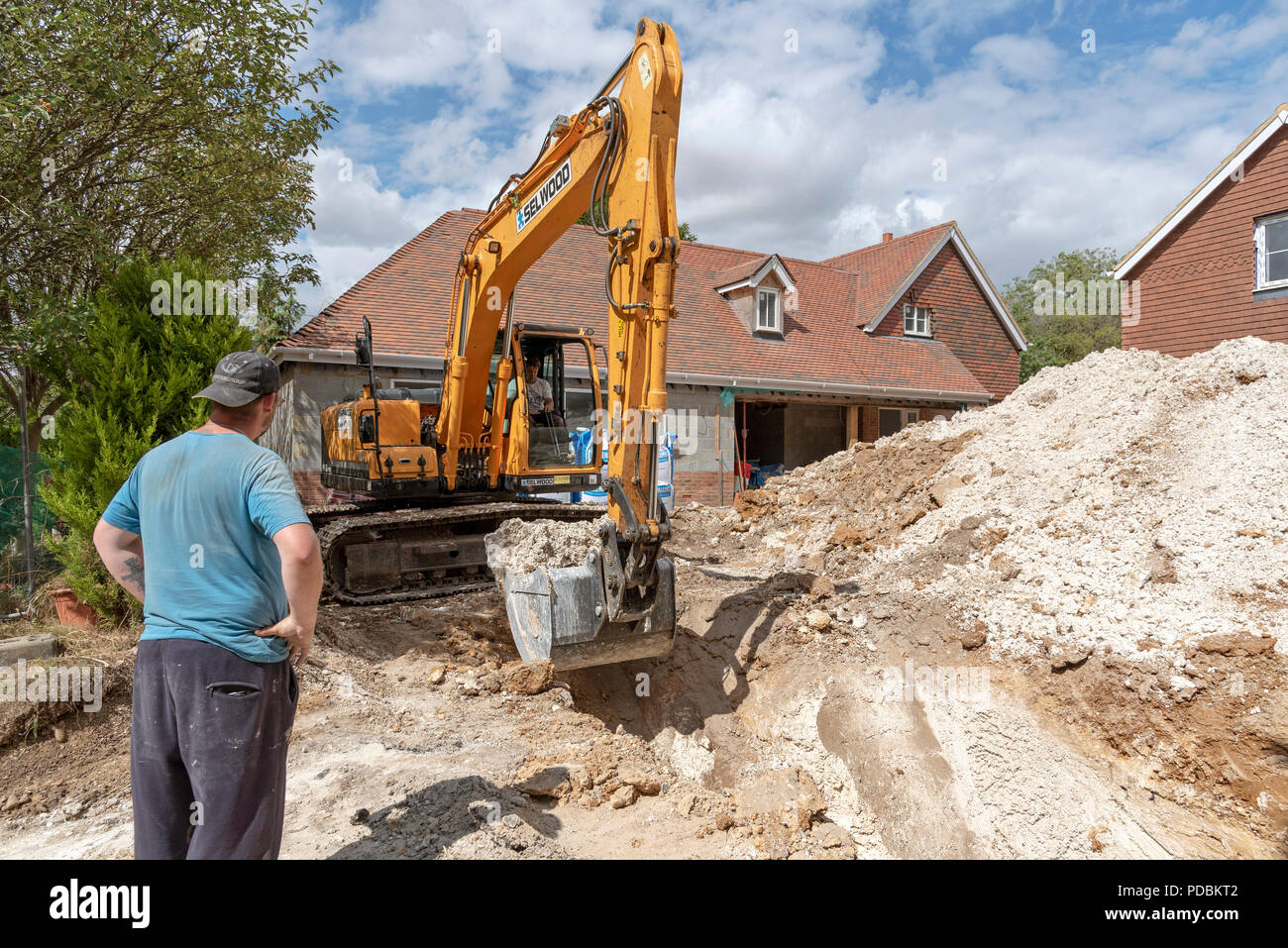 A Excuvator crawler digging a trench for an underground tank on a ...