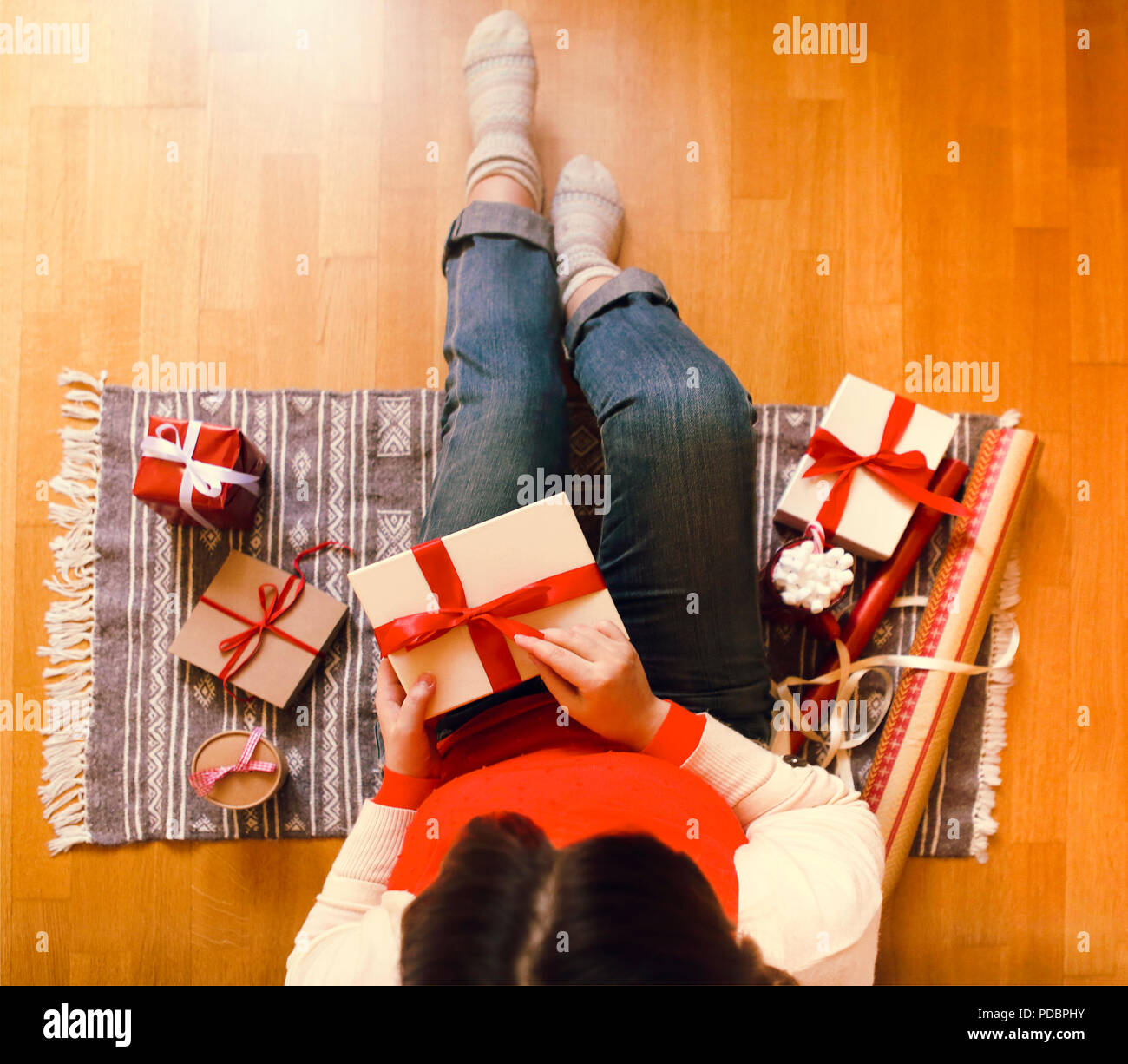 Young woman packing presents in Christmas time. Top view Stock Photo ...