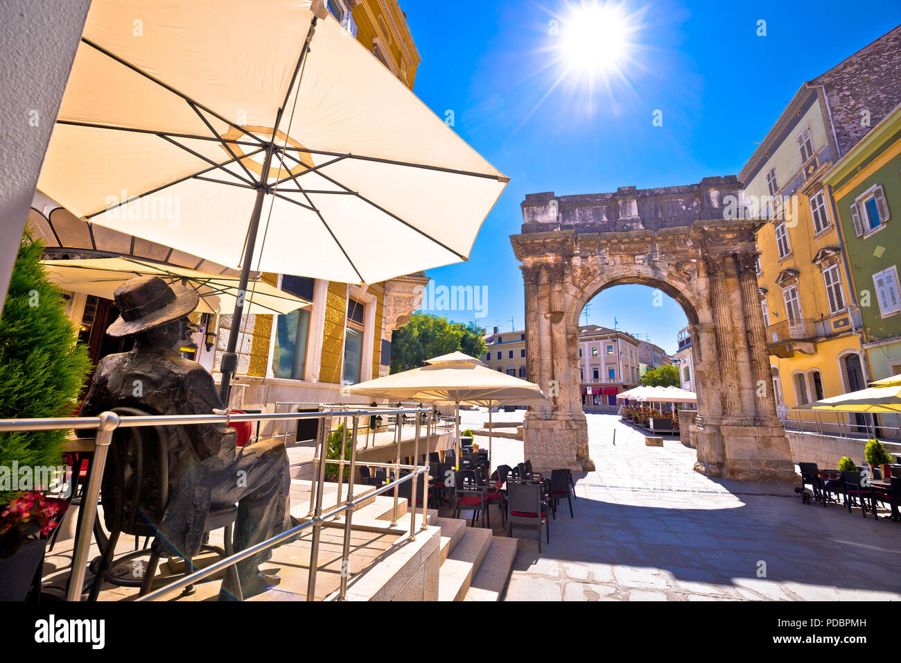 Street of Pula with historic Roman Golden gate and James Joyce statue ...