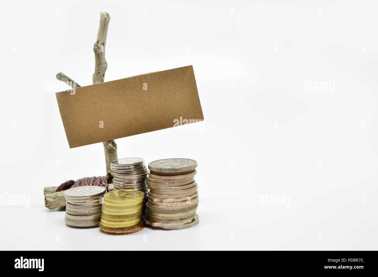 Paper sign board with stack of coins on white background Stock Photo ...