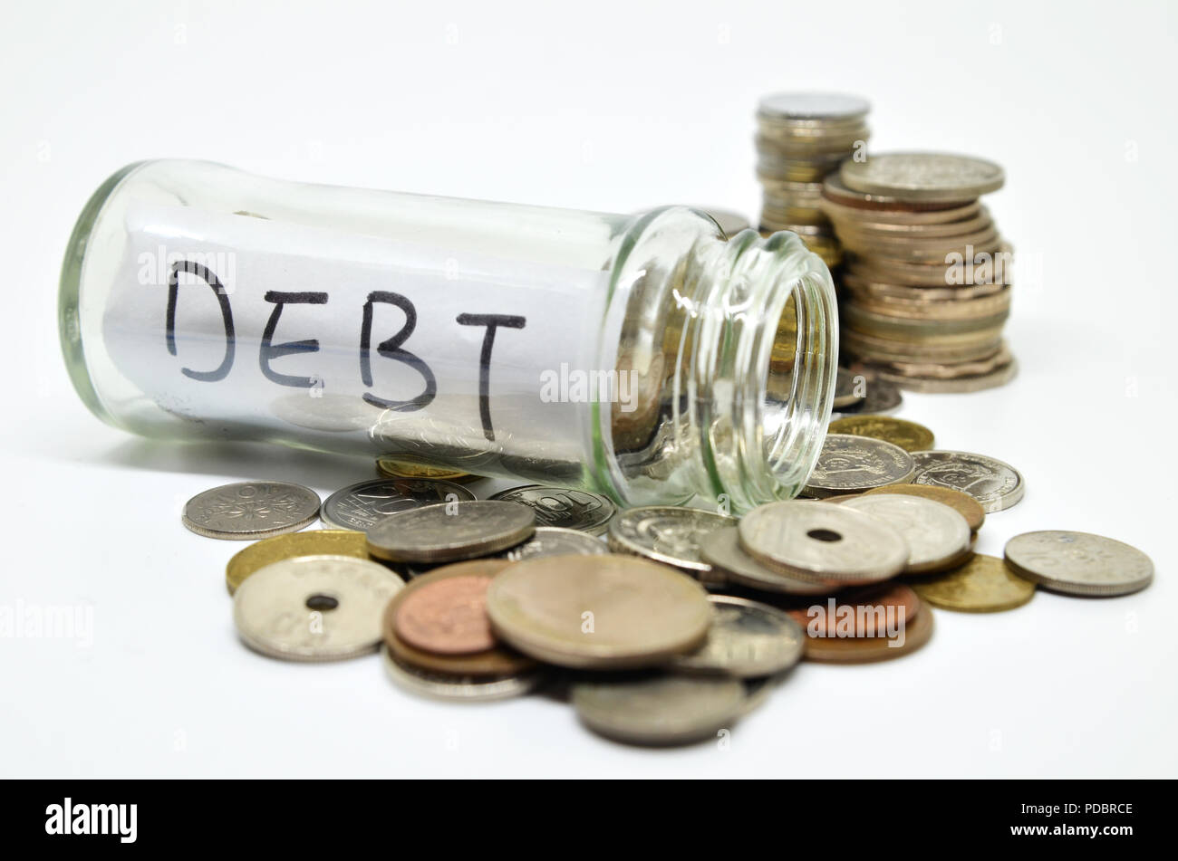 Debt lable in a glass jar with coins spilling out isolated on white ...