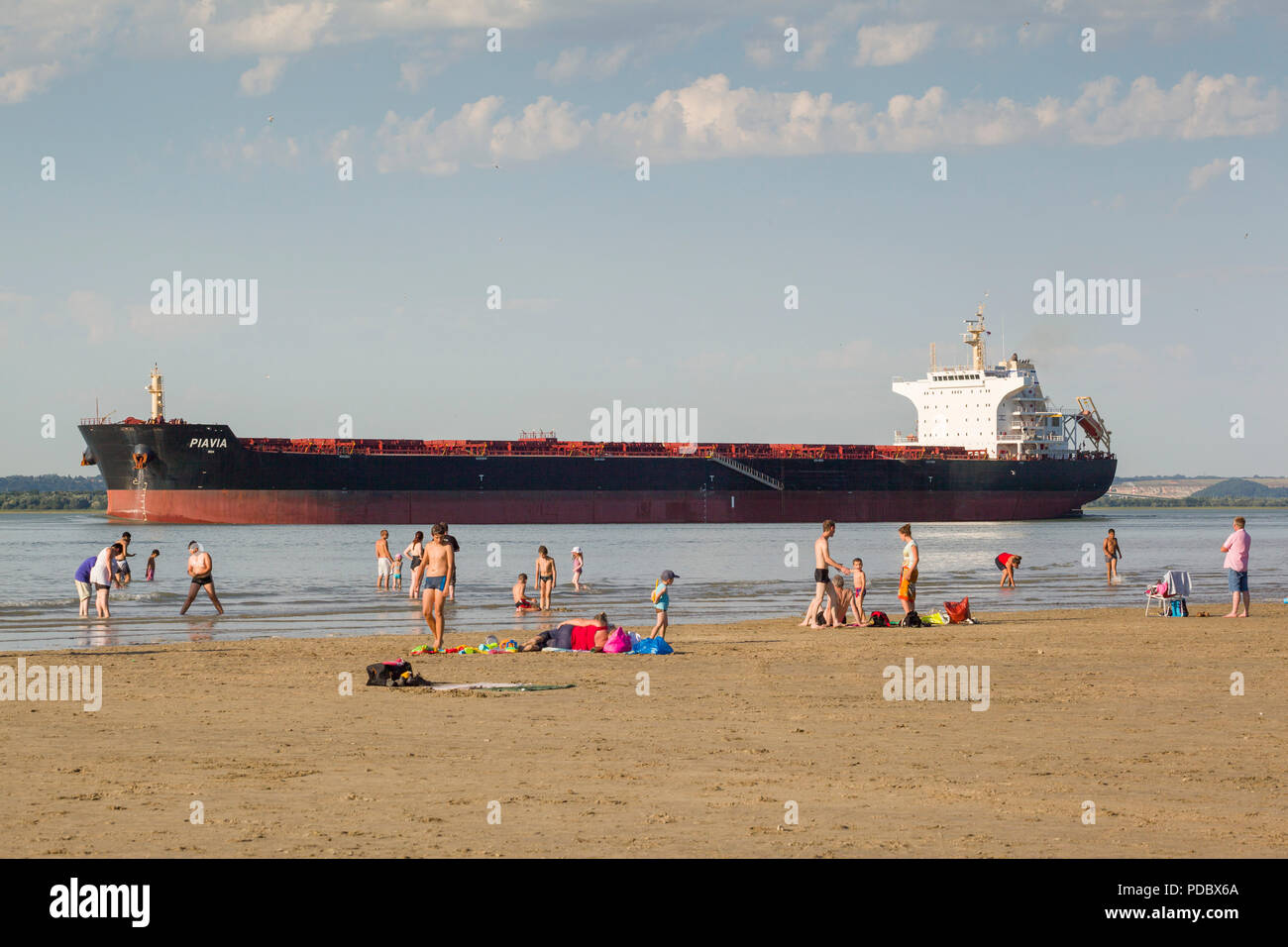 Holidaymakers walk along the beach, the Plage du Butin, at Honfleur as ...