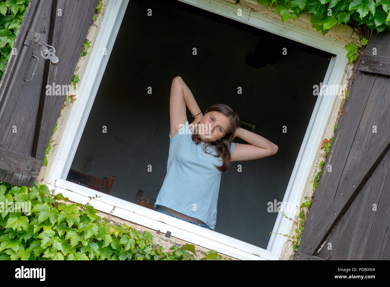 a teenage girl opening the window in the morning Stock Photo - Alamy