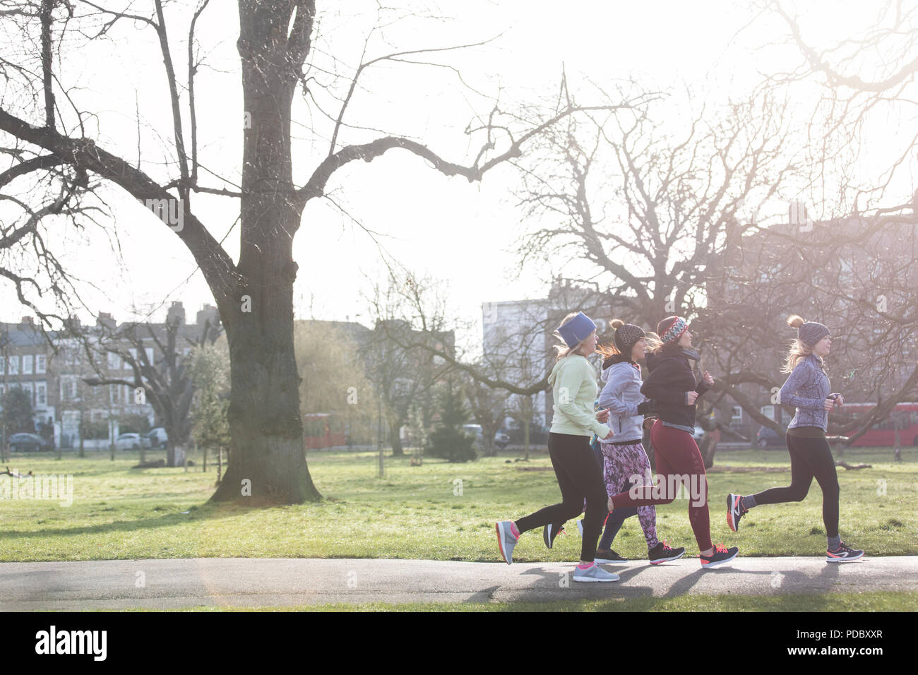 Female runners running in sunny park Stock Photo - Alamy