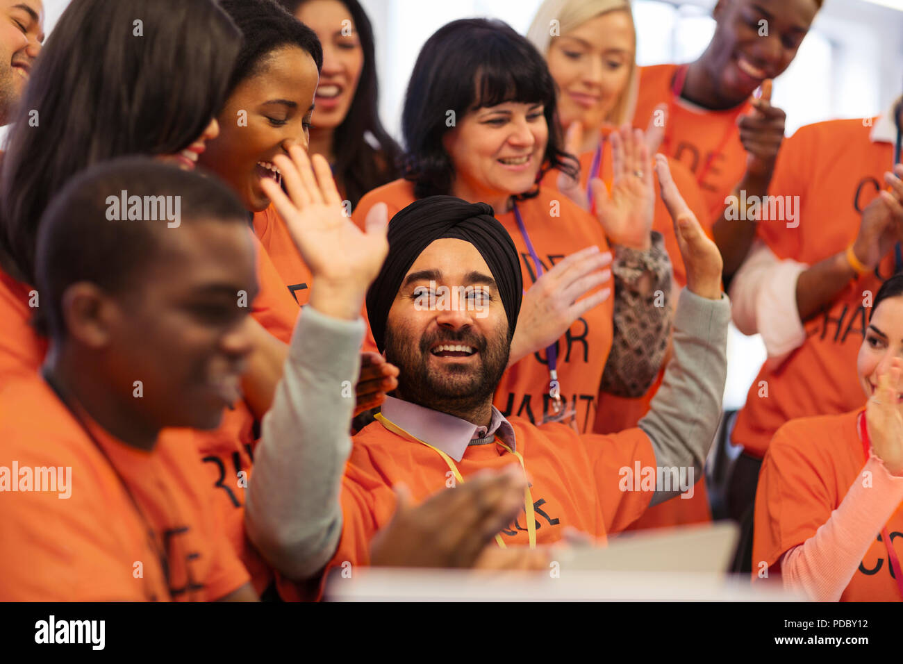 Happy hackers cheering and celebrating, coding for charity at hackathon ...