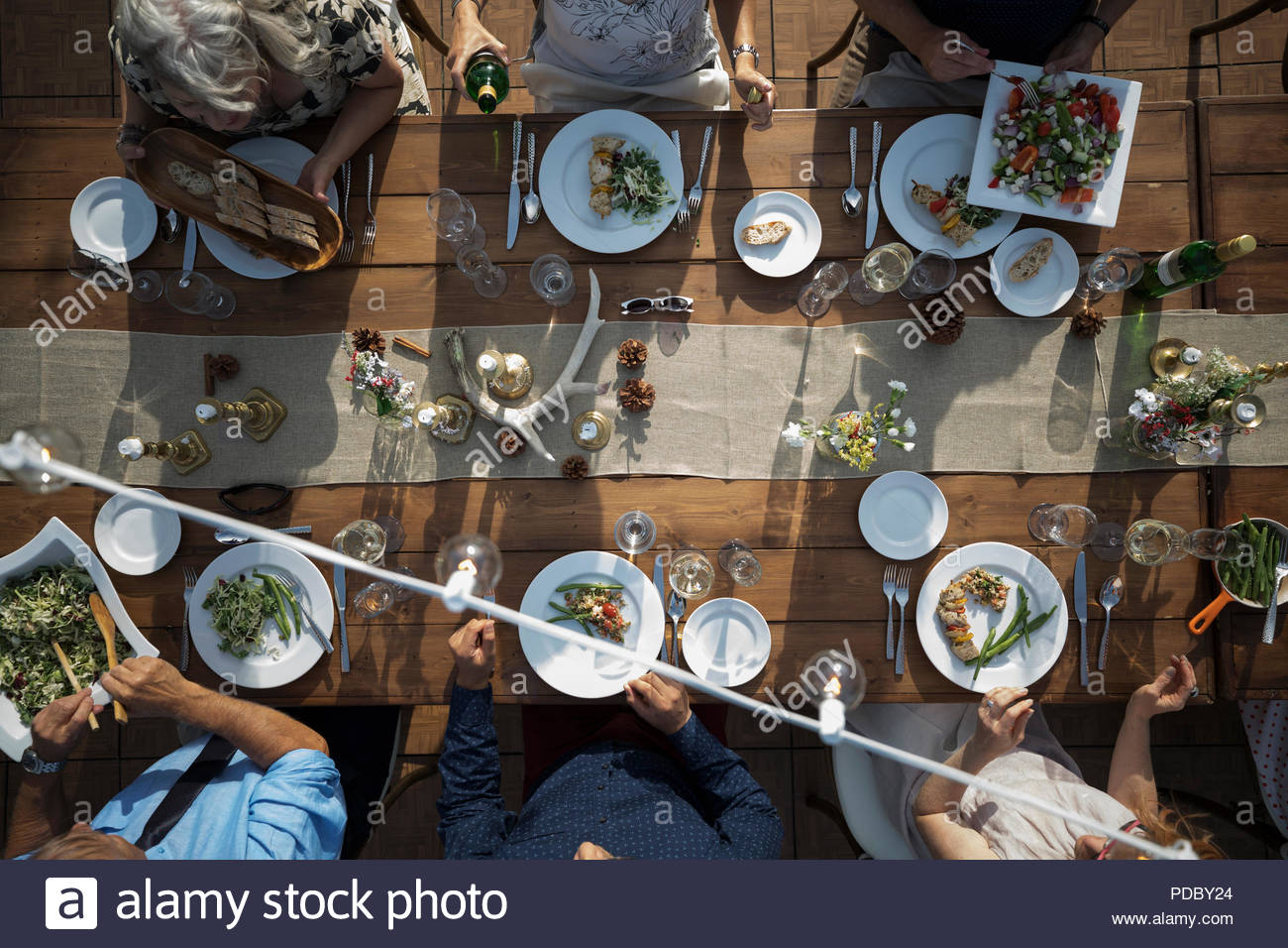 Overhead view friends enjoying lunch and wine at patio table Stock ...