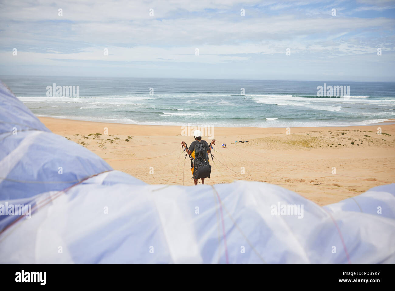 Paraglider with parachute on ocean beach Stock Photo - Alamy