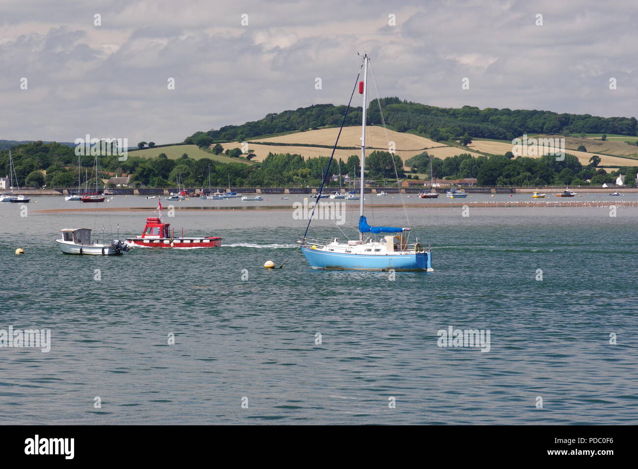Rolling Patchwork Devon Farmland beyond a Blue Yacht Moored on the Exe ...