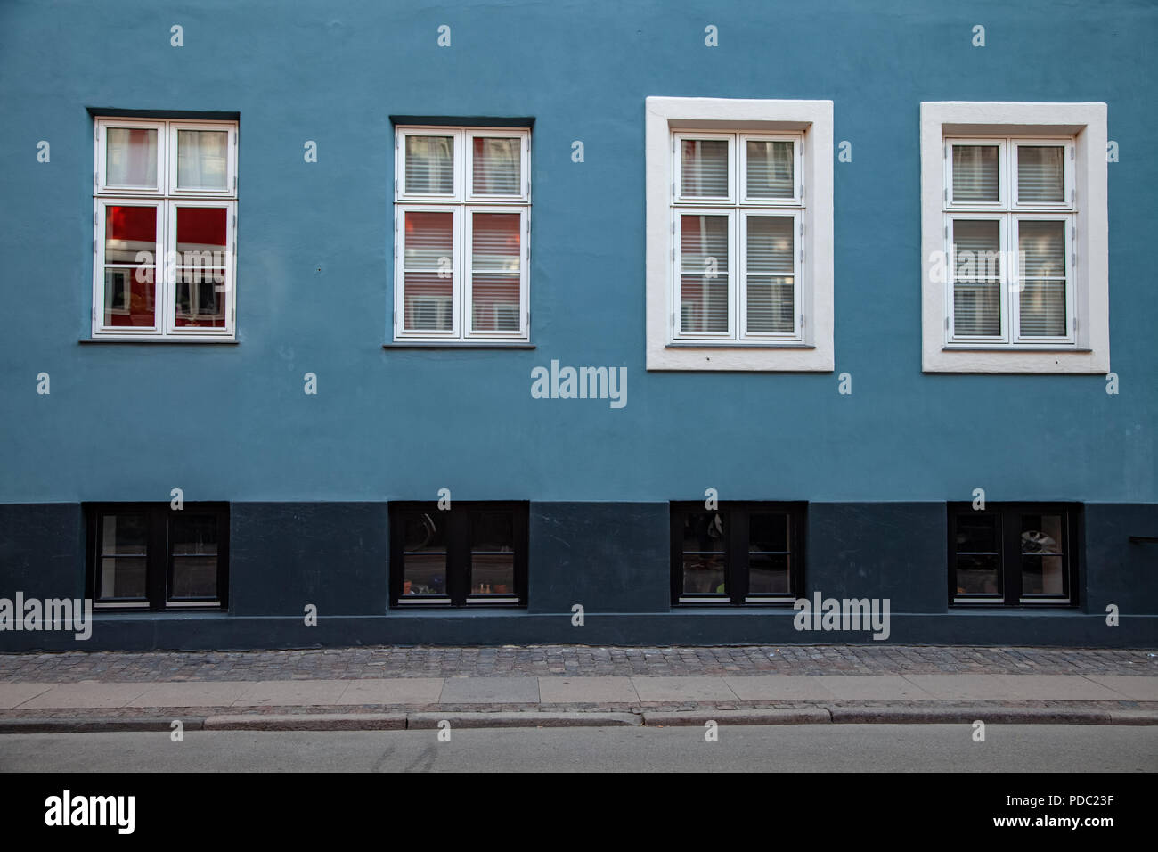 detail of blue and grey building with white windows on street in ...