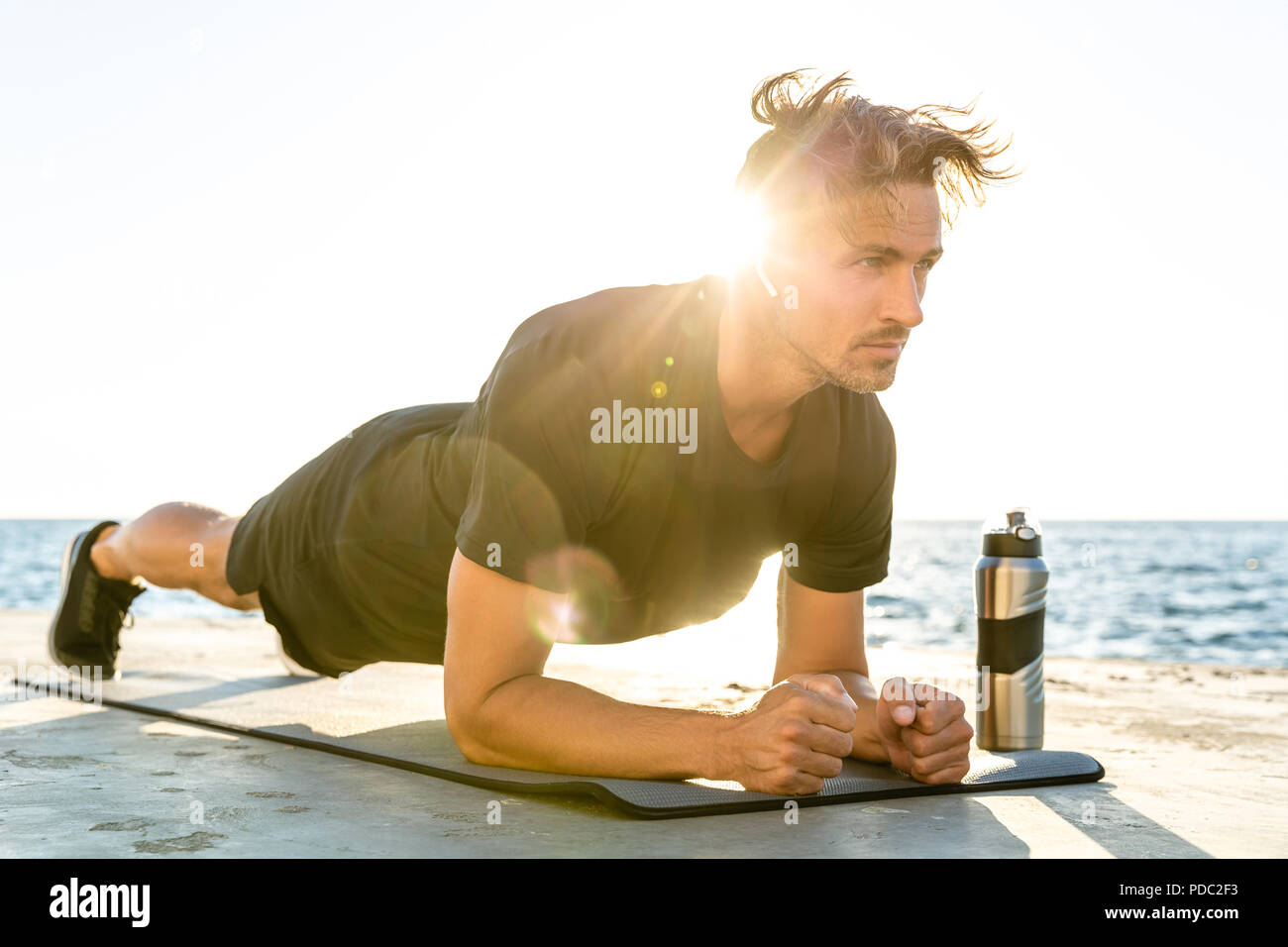 sporty adult man doing plank exercise on seashore Stock Photo - Alamy