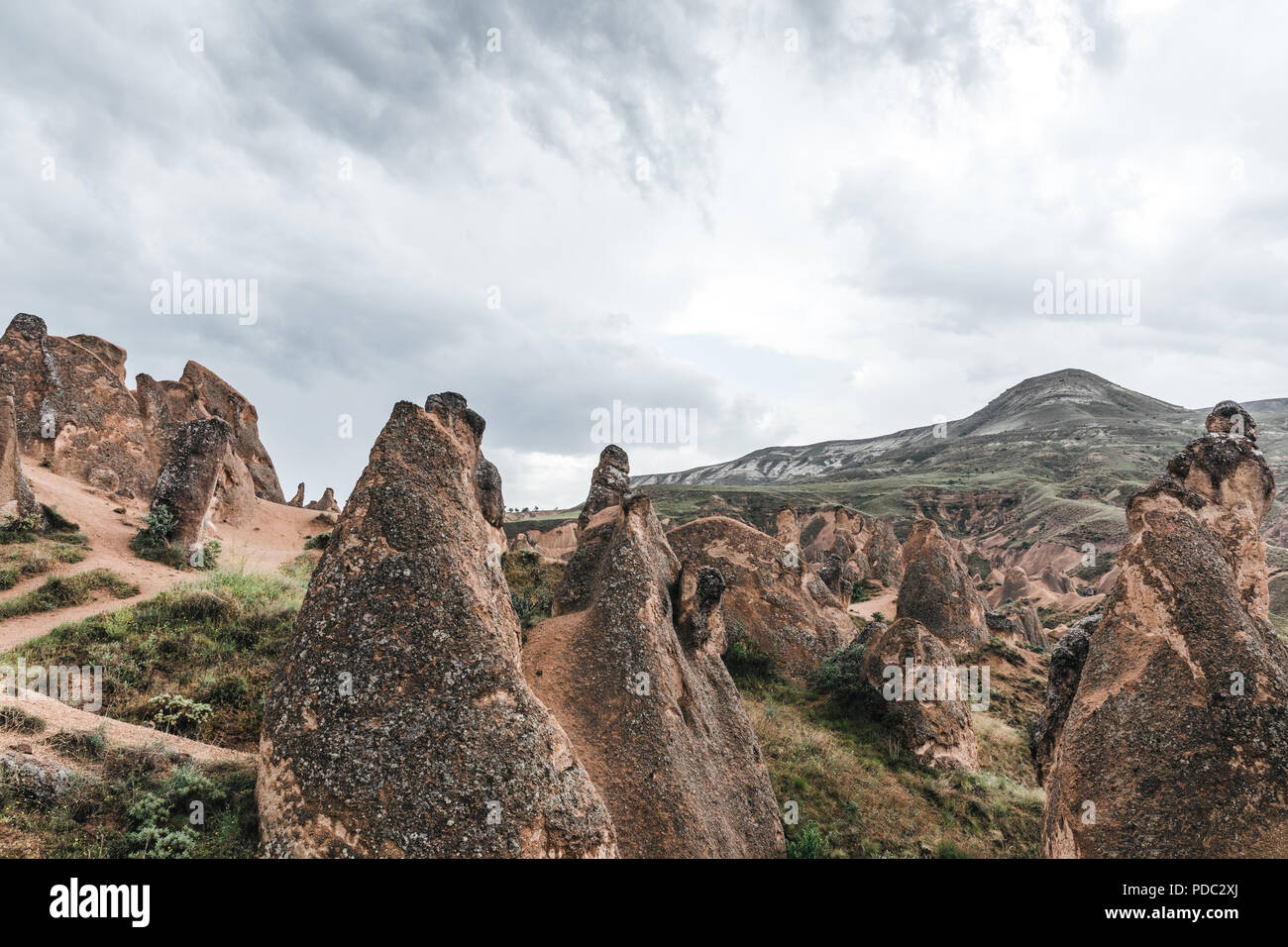 majestic geological formations and cloudy sky in cappadocia, turkey ...