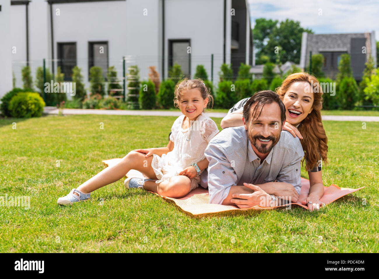 Nice positive family lying on the ground together Stock Photo - Alamy