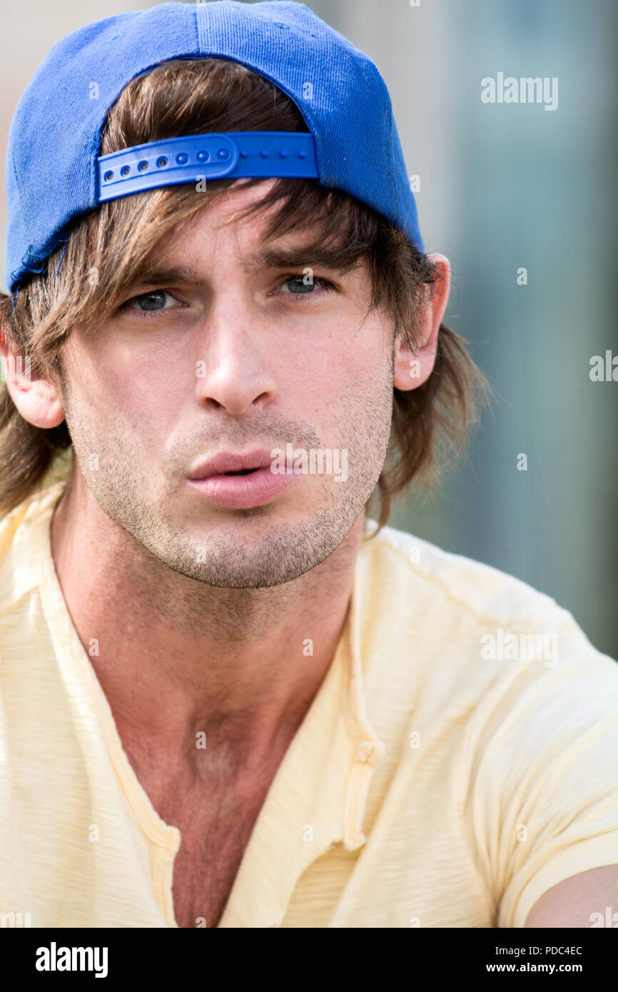 Portrait of an athletic handsome young man in a ball cap. Exclusive ...