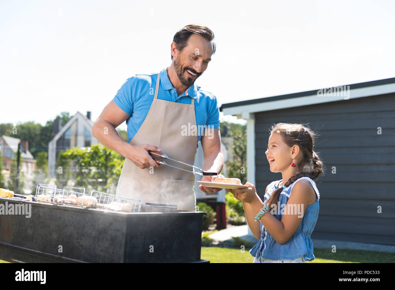 Delighted joyful man putting food on the plate Stock Photo - Alamy