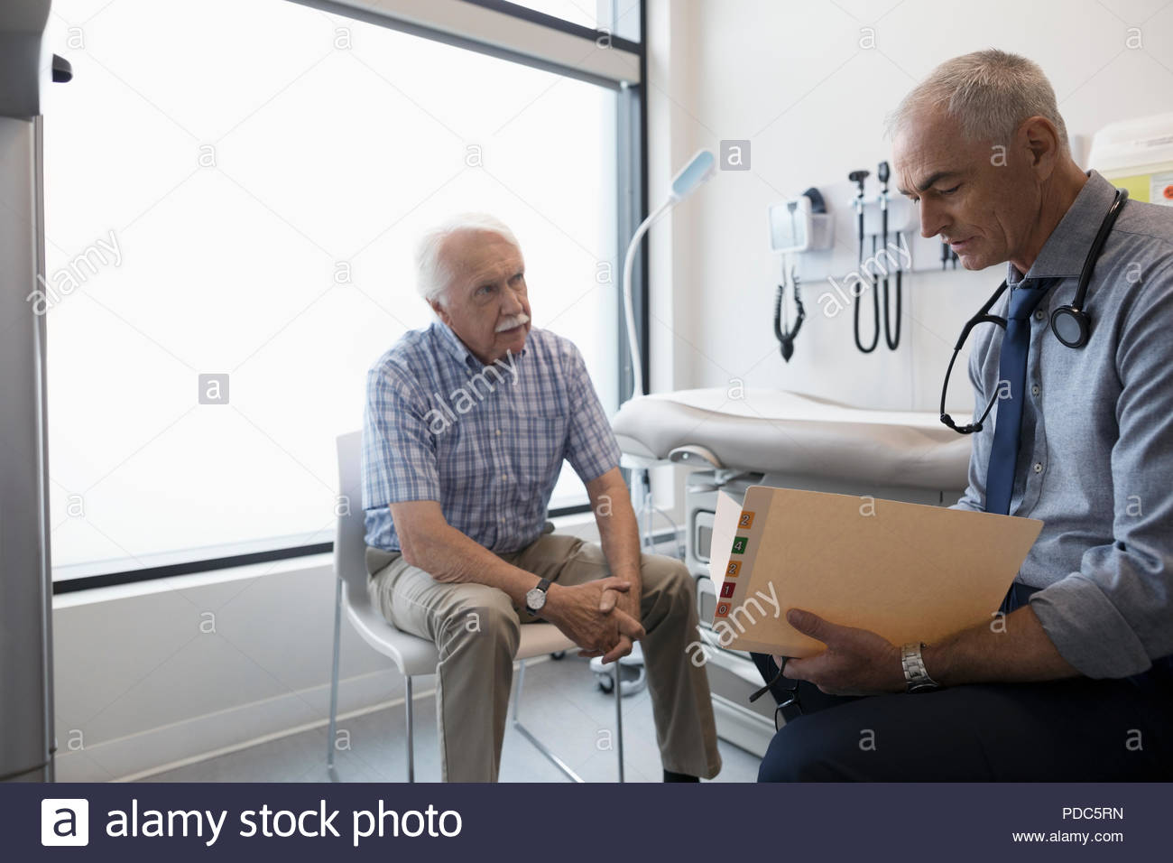 Doctor reading patient record hi-res stock photography and images - Alamy