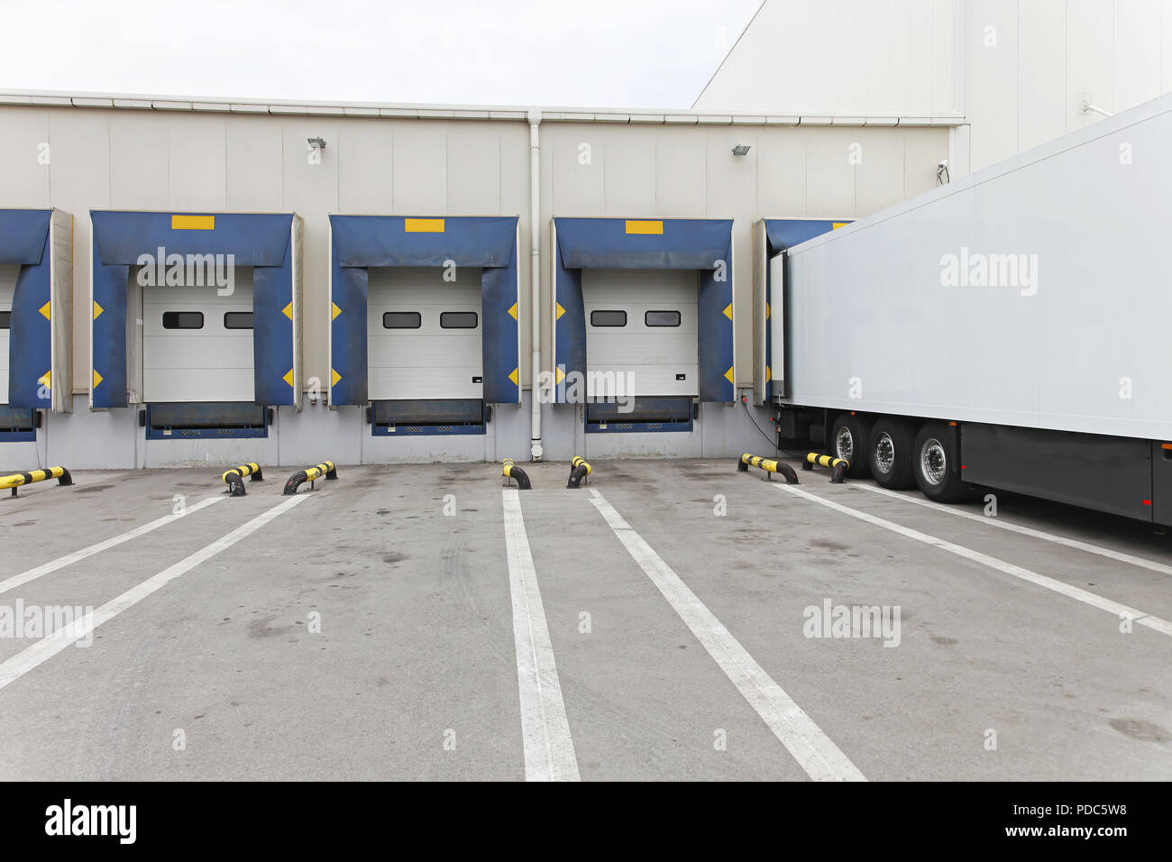 White semi truck trailer at warehouse loading dock Stock Photo - Alamy