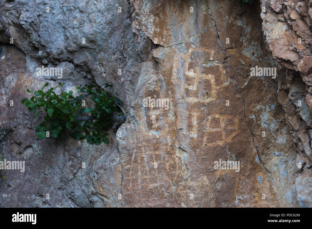 Ancient prehistoric archaeological rock drawings on cliff face of ...