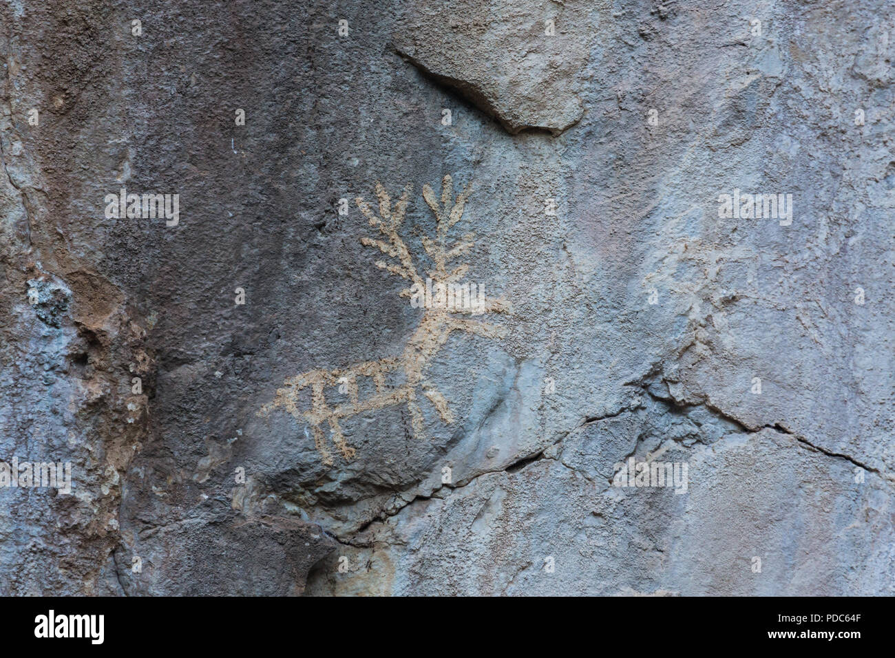 Ancient prehistoric archaeological rock drawings on cliff face of ...