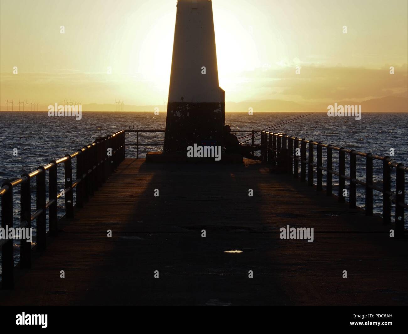 The sun setting behind a Sea Angler and the Navigation Beacon, Maryport ...