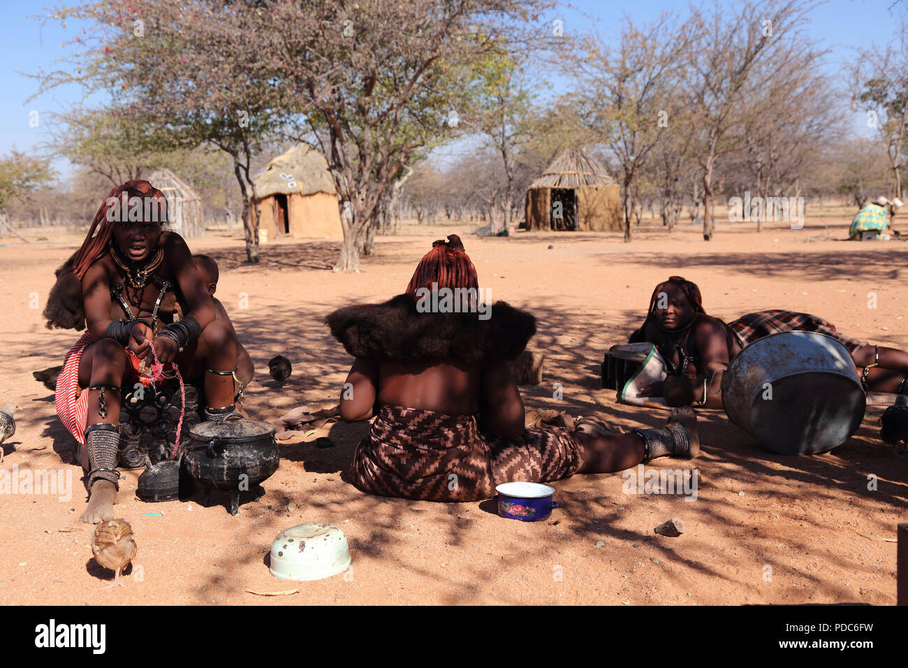 Himba women, Otjikandero village, northern Namibia. Red ochre paste is ...