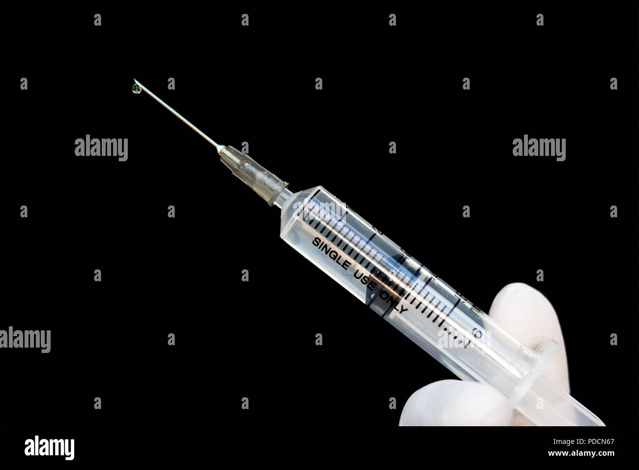Syringe in a hand in medical gloves, ready for injection with ...