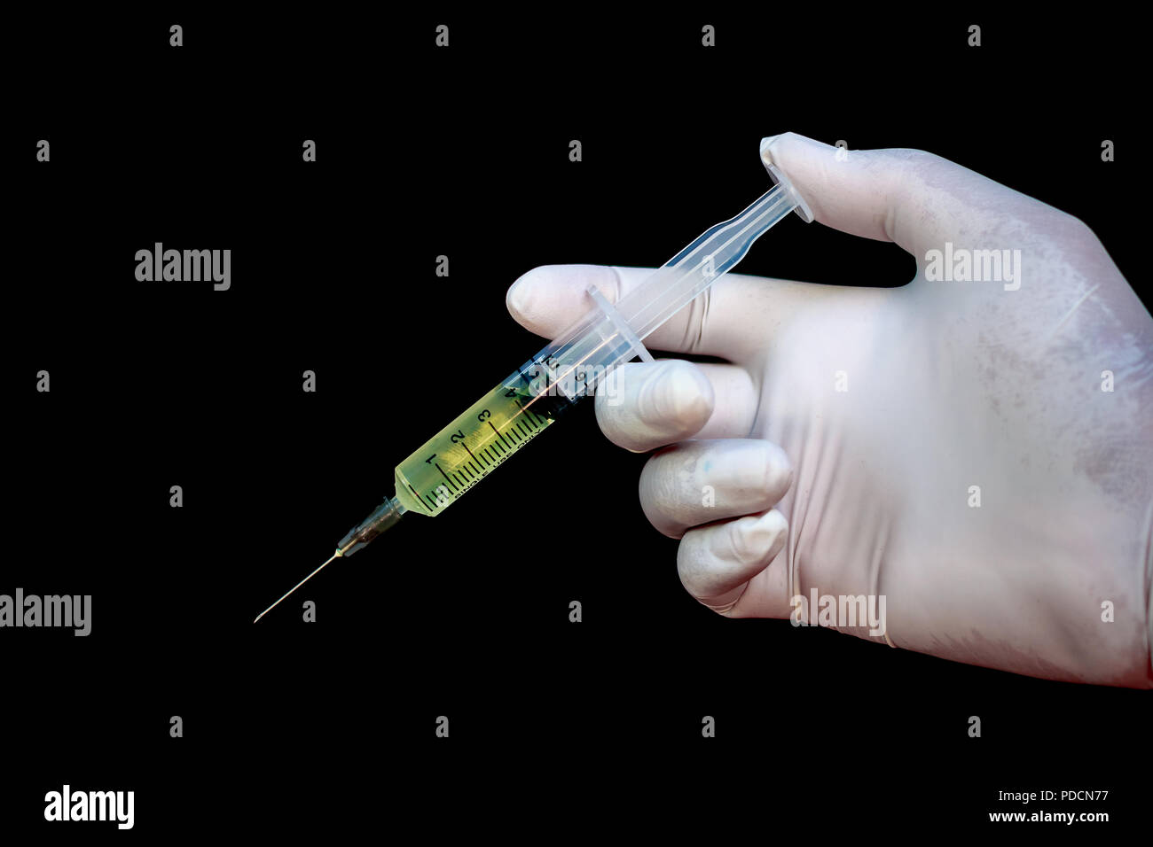 Syringe in a hand in medical gloves, ready for injection with ...