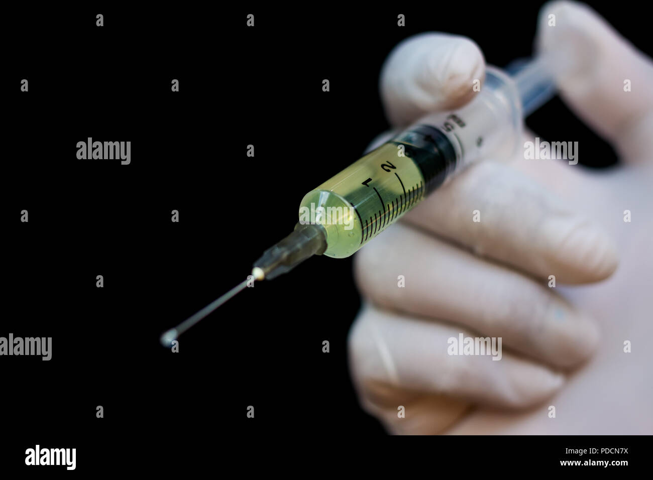 Hand hold medical syringe. Black isolated studio shot Stock Photo - Alamy