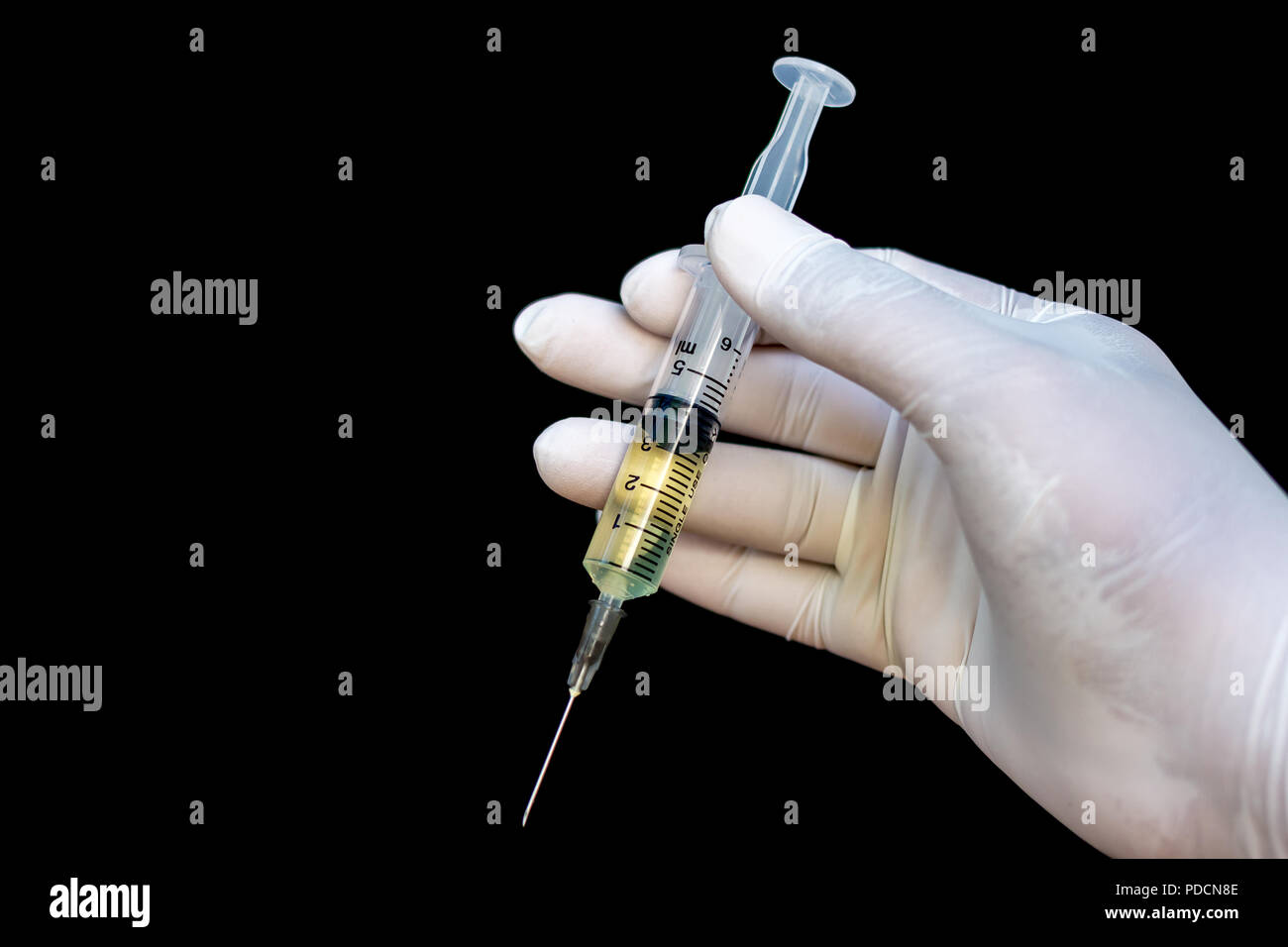 Syringe in a hand in medical gloves, ready for injection with ...