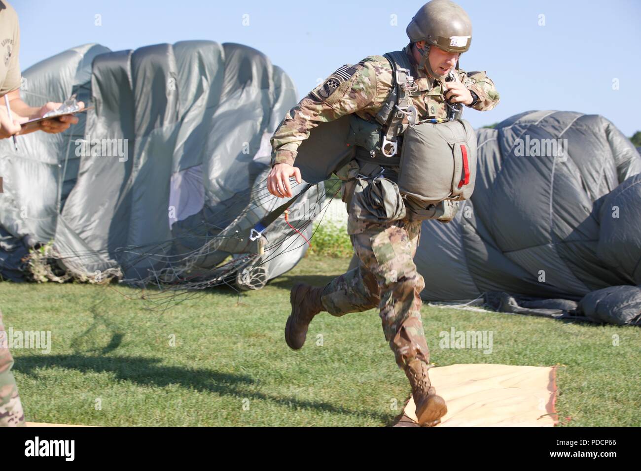 A U.S. Army Paratrooper runs onto the X with his MC-6 parachute on ...